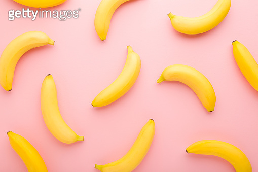Beautiful fresh yellow bananas on light pink table background. Pastel ...