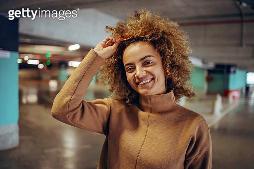 Portrait of smiling mixed race rap girl standing in garage and looking ...