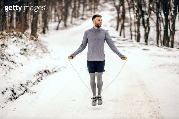 Sportsman skipping the rope in nature at snowy winter day. Winter ...