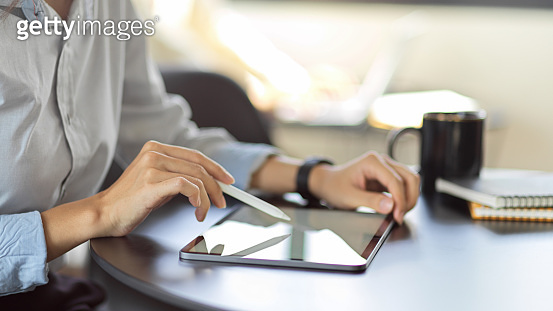 Female using mock up blank screen digital tablet while working on her ...