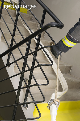 the fireman's hand secures the fire line to the railing in the ...