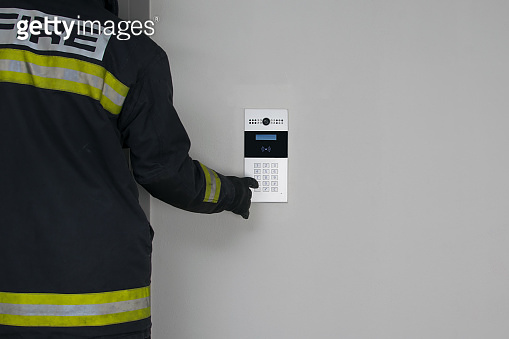 close-up of the intercom button, the fireman's hand presses, there is a ...