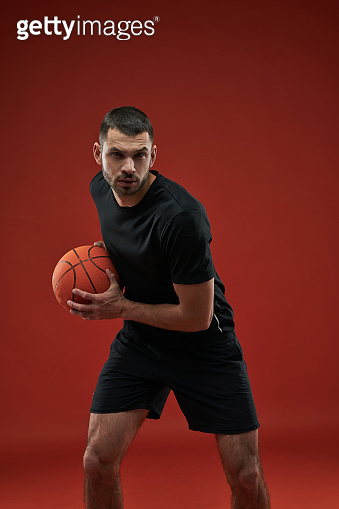 Focused cheerful basketball player looking at the photo camera while he ...