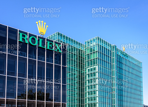 The Rolex logo at the top of the headquarters building in Geneva ...