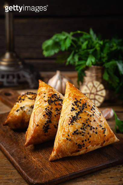 Close-up baked national asian pie samsa with meat, sesame, traditional ...
