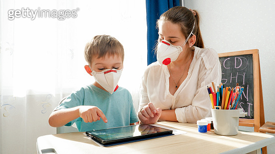 Little boy wearing protective medical mask respirator studying in ...