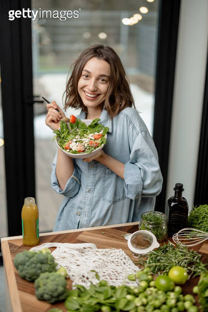 Woman eating healthy green salad at home 이미지 (1299812788) - 게티이미지뱅크