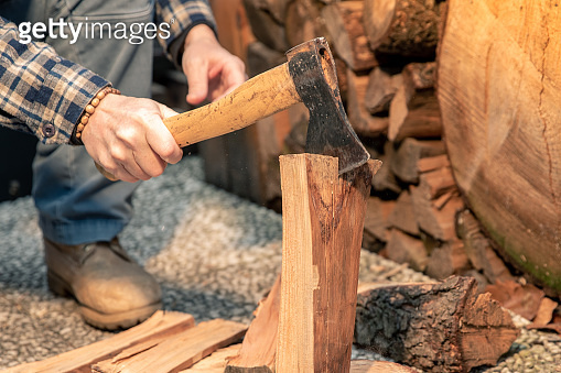 Man uses ax to break wood to use for bbq. Preparation of wood to light ...