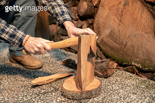 Man uses ax to break wood to use for bbq. Preparation of wood to light ...