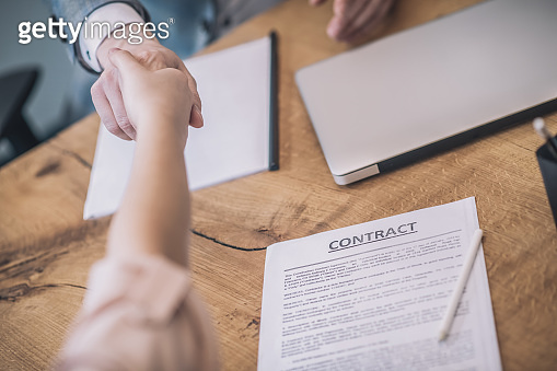 Male and female hands in handshake over contract 이미지 (1319259667) - 게티이미지뱅크