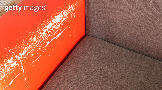 Torn and battered leather back of the sofa. Poor quality leather ...