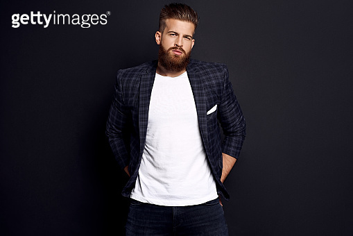 Handsome man with perfect hairdo and beard looking at camera while ...
