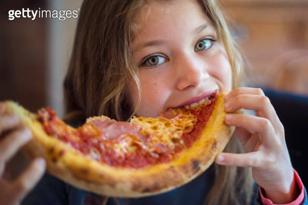 portrait of a pretty young girl devouring a pizza (1316259467) - 게티이미지뱅크