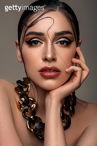 beautiful woman with evening glamorous make-up with a huge chain on her ...