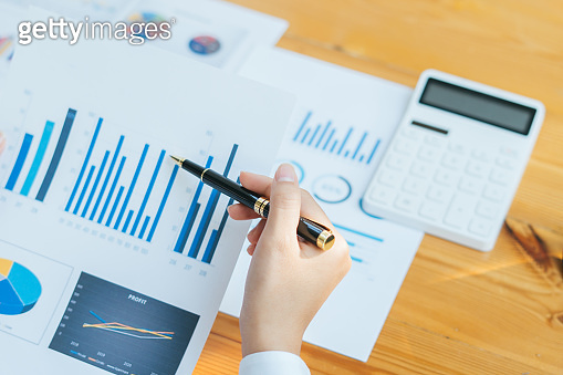 Businessmen are analyzing graphs and taking notes with charts and ...