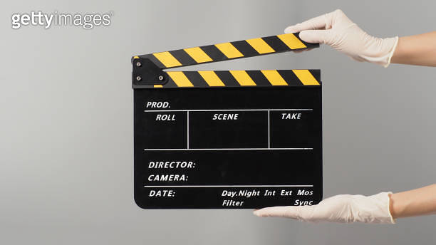 Hand is holding black clapper board and wear medical glove.It is used ...