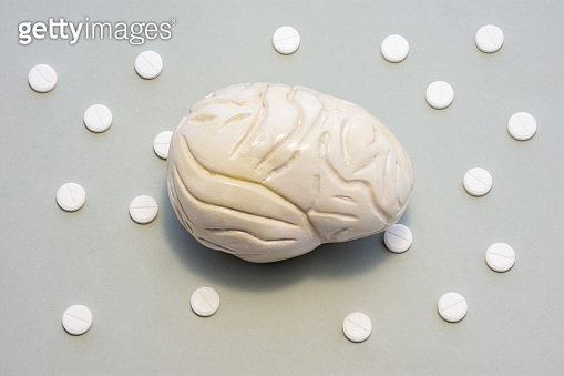 Brain on gray background with tablets in pattern of polka dots. Photo ...