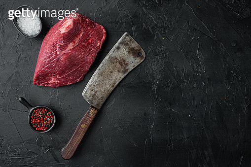 Round beef meat raw with old butcher cleaver knife, on black background ...