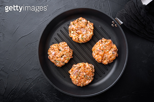 Quick asian raw fish patties with herbs, on black textured background ...