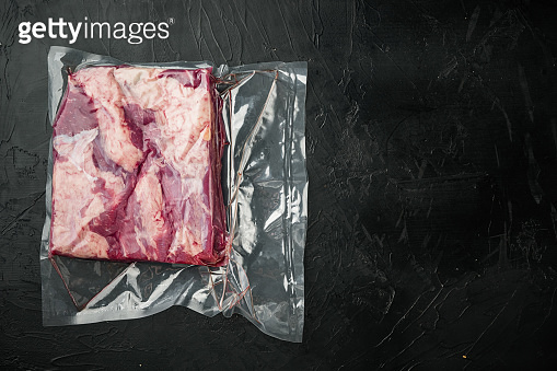 Cryovac packed meat Beef brisket in vacuum, on black stone background ...
