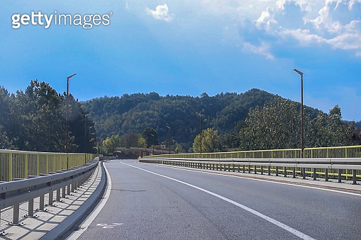 Asphalt road with two lane on a sunny day, blue cloudy sky background ...