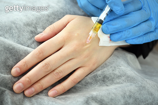 A plastic surgeon doctor does an injection of a beauty injection into ...