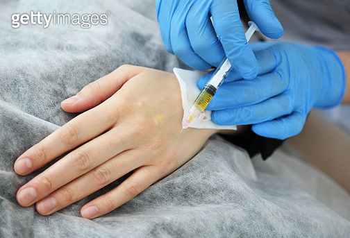 A plastic surgeon doctor does an injection of a beauty injection into ...