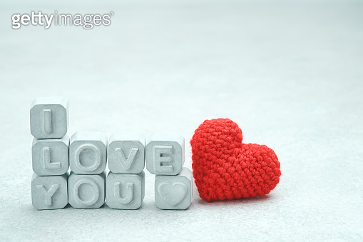Phrase I love you made of gray concrete letters. Crochet red heart ...