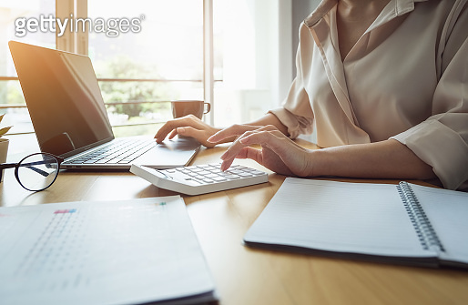 Business woman using calculator to review balance sheet annual using ...