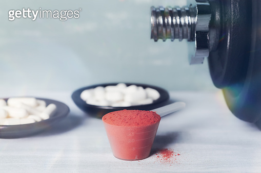 Creatine Powder, Aginine capsules, BCAA (amino acids) and a dumbbell in ...