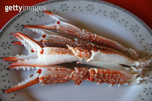 cooked crab claws on a plate. one claw in focus the rest out of focus ...