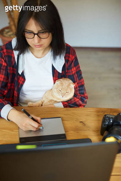 Creative female photographer with cute cat, using graphic drawing ...