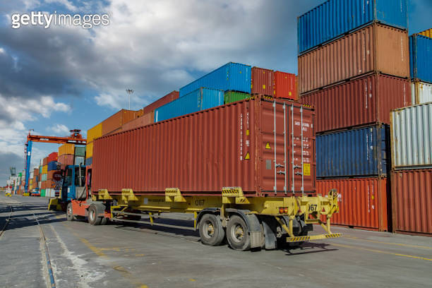 Trucks being loaded or unloaded with containers at commercial port. 이미지 ...