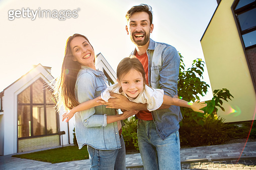 Urban Village. Family of three mother and father holding daughter ...