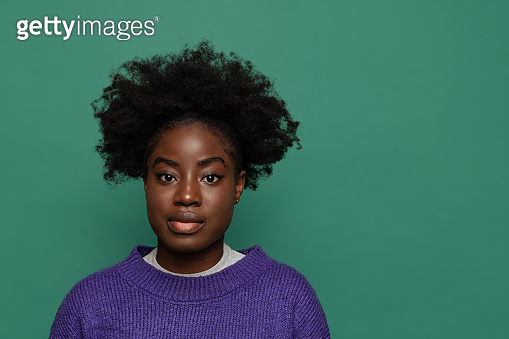 Close-up African young girl's portrait on dark green studio background ...