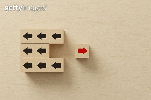 Wooden block with red arrow facing the opposite direction black arrows ...