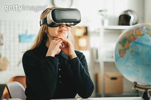 Handsome woman using vr headset and world map dreaming of travel to any ...