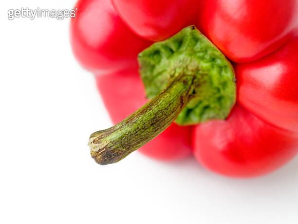 Ripe red bell pepper with a green dried stalk is isolated on a white ...