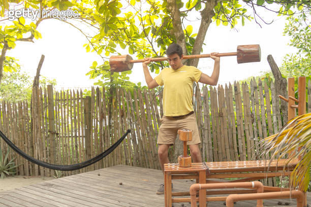 Young strong fit athletic man lifting and doing a workout exercises ...
