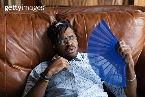 Close up exhausted African American man waving paper fan (1303905847 ...