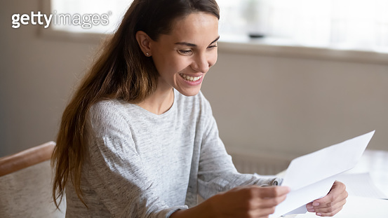 Smiling millennial woman is glad reading letter from beloved person 이미지 ...