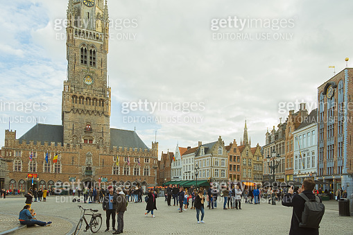 crowd tourists walking in Grote Markt square and Belfort tower in ...