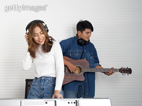 Young asian woman sing while playing an electric keyboard in front of ...