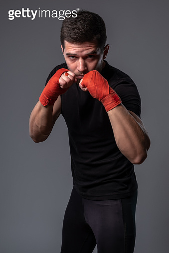 Man with wrist wraps on hands standing in orthodox boxing stance ...