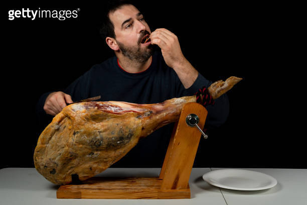 Bearded man with a ham knife ready to cut a piece of typical Spanish ...