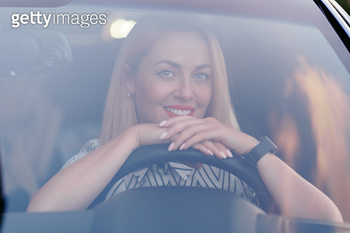Woman driving a car, view through front window 이미지 (1318116858) - 게티이미지뱅크