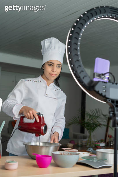 Female influencer chef speaks to her followers while doing a live show ...