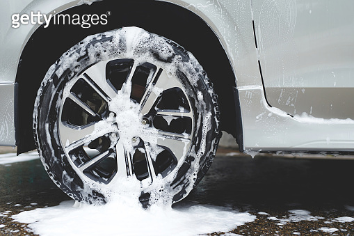 Car wash with active foam soap. cleaning wheel tire. commercial ...