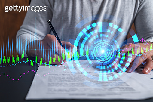 Double exposure of man signing contract and financial graph hologram ...