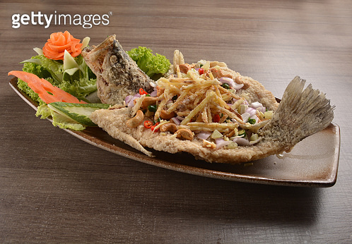 deep fried crispy whole grouper fish with mango salad dressing on wood ...